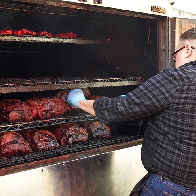 The pitmaster's dance&mdash;checking, turning, and tending to meat that transforms from ordinary to extraordinary through smoke, time, and expertise. 