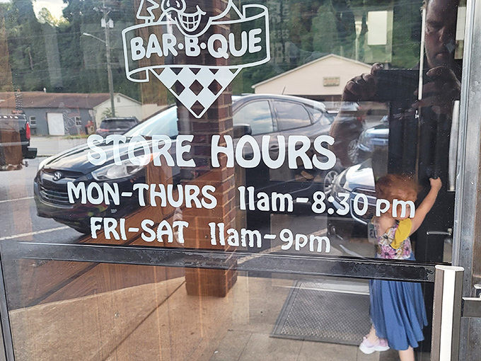 Store hours painted on glass &ndash; the most important information for barbecue pilgrims. Note the extended weekend hours for serious smoked meat devotion. 
