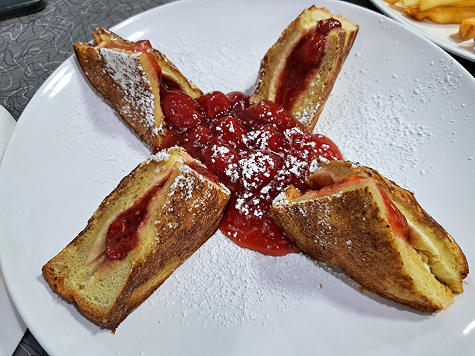 Stuffed French toast arranged like a star, crowned with strawberry topping and powdered sugar &ndash; breakfast that doubles as edible art.