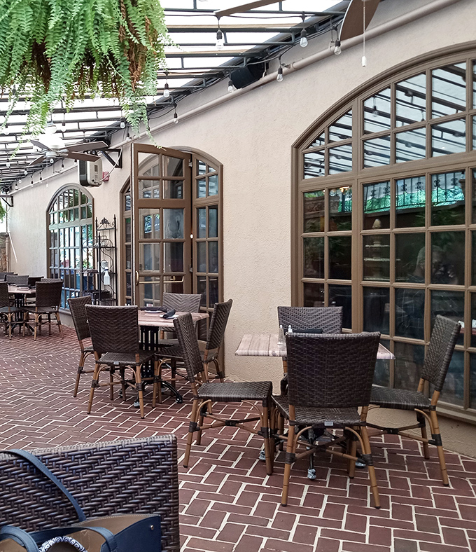 Sunlight streams through arched windows onto herringbone brick floors, creating the kind of dining atmosphere that makes everything taste even better.