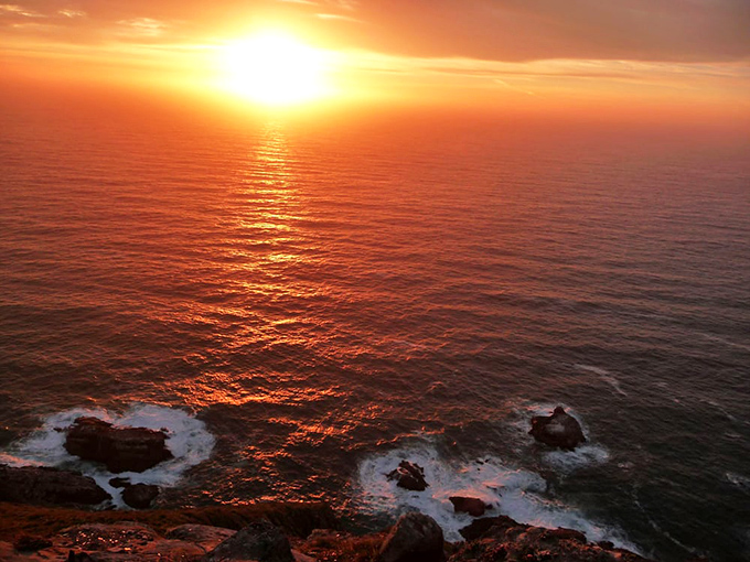 Nature's light show outshines any man-made beacon as the sun melts into the Pacific, painting the water in impossible shades of liquid gold.