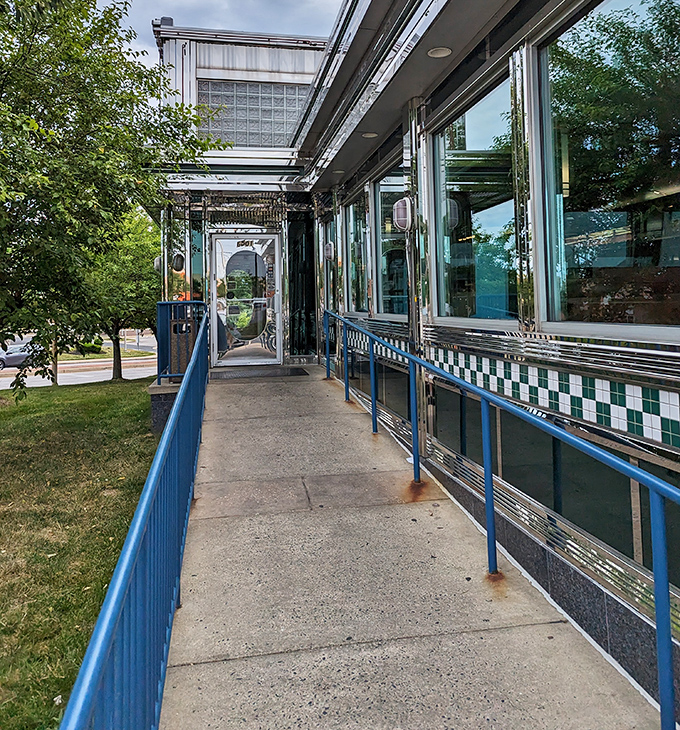 Blue railings guide you toward breakfast paradise, where chrome and comfort converge in perfect diner harmony ahead.