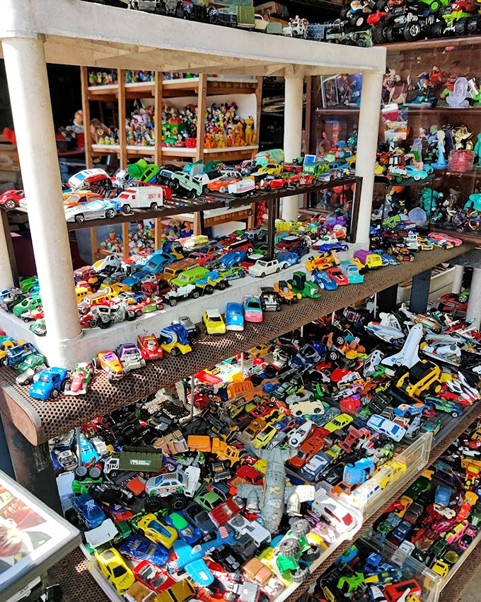 Toy car collection that would make any collector's inner child do donuts with delight. Decades of miniature automotive history spread across multiple shelves.