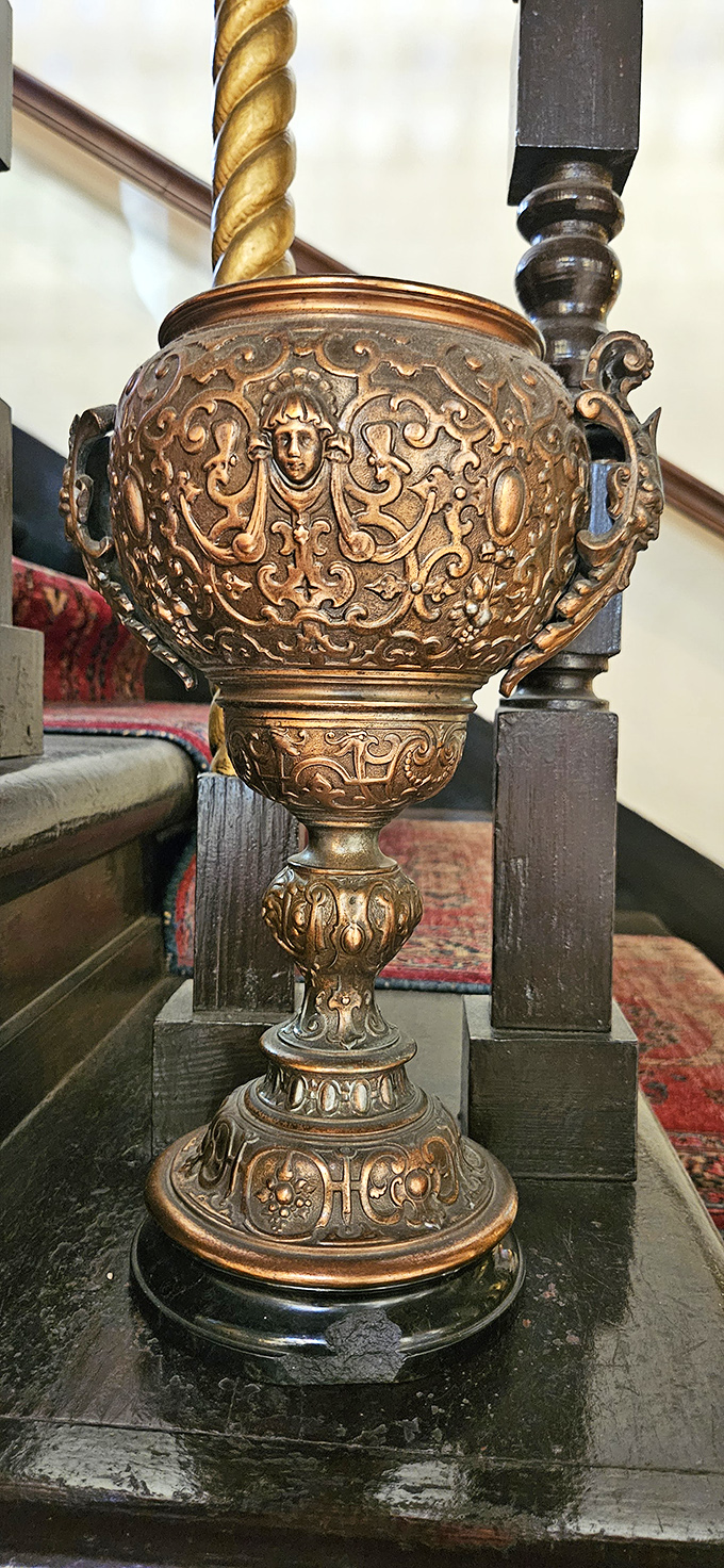 This ornate bronze cassolette features faces that have been watching visitors for generations, silently judging your choice of footwear.