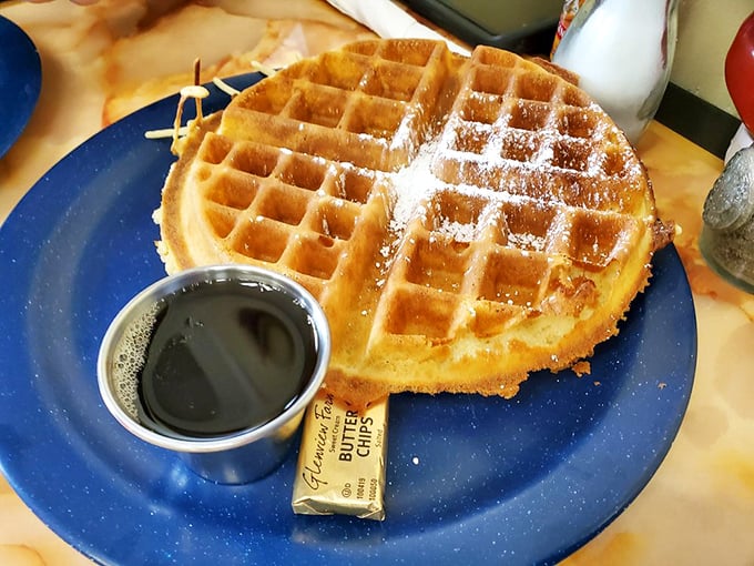 This golden waffle isn't just breakfast&mdash;it's an edible sunbeam, dusted with powdered sugar and served with maple syrup for proper morning bliss.