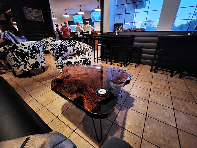 A live-edge wood coffee table anchors the lounge area, where cowhide chairs invite you to settle in before the main event.