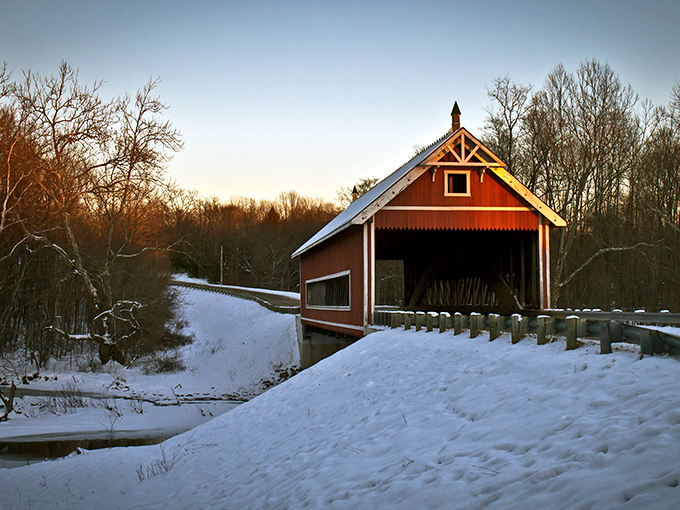 Winter transforms the bridge into something from a holiday card, the red siding popping dramatically against pristine white snow.