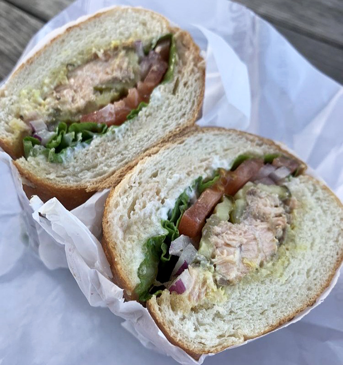 The salmon sandwich proves BBQ mastery extends beyond land animals. Ocean meets smoke in this handheld masterpiece of flavor.