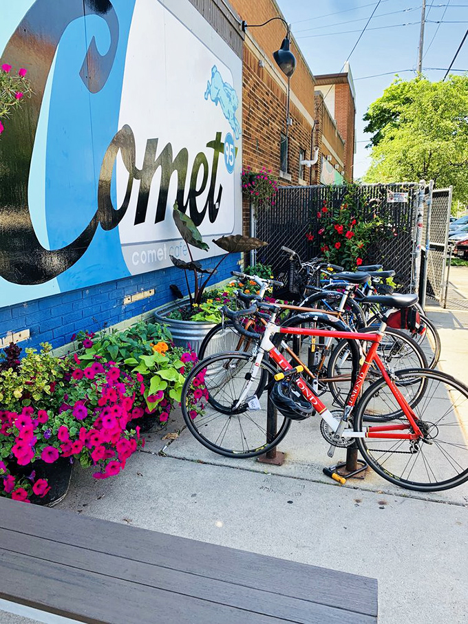 The vibrant mural and flower planters create a colorful welcome. Bicycles clustered nearby suggest this is where the locals love to gather.