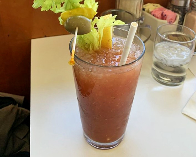 A Bloody Mary garnished with celery and olives—breakfast's favorite cocktail, standing tall and proud like a morning achievement.