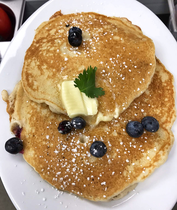 Blueberry pancakes with that golden-brown perfection that makes you wonder if the chef has some sort of pancake superpower. Butter melting like a dream.
