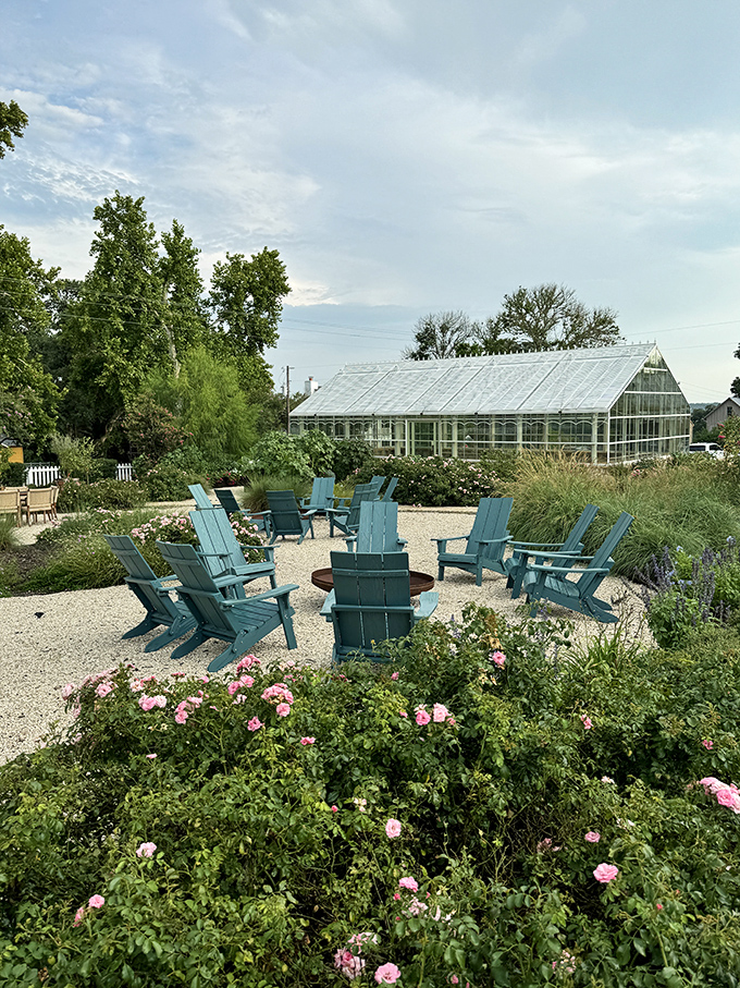 Garden seating surrounded by roses and a greenhouse view - Round Top's version of paradise for weary antique hunters.