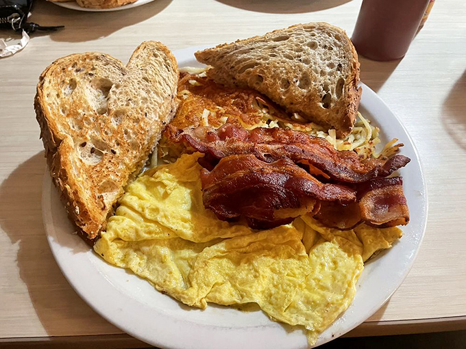 The classic breakfast trinity&mdash;perfectly scrambled eggs, crispy bacon, and golden toast&mdash;proving that sometimes simplicity is the ultimate sophistication.