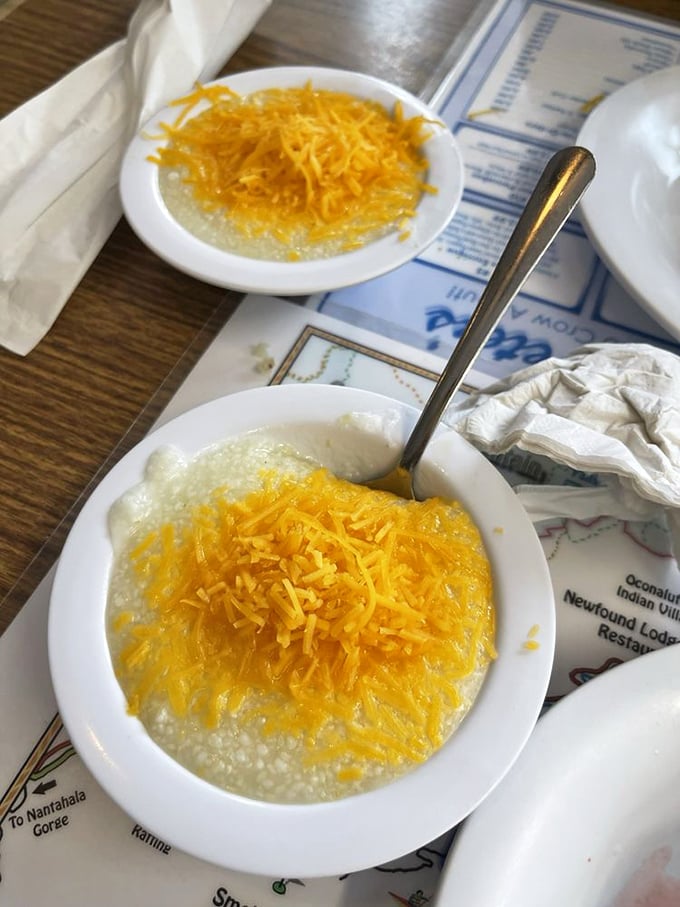 Grits topped with a snowcap of shredded cheddar slowly melting into creamy goodness. Southern comfort in a bowl that warms both body and soul.