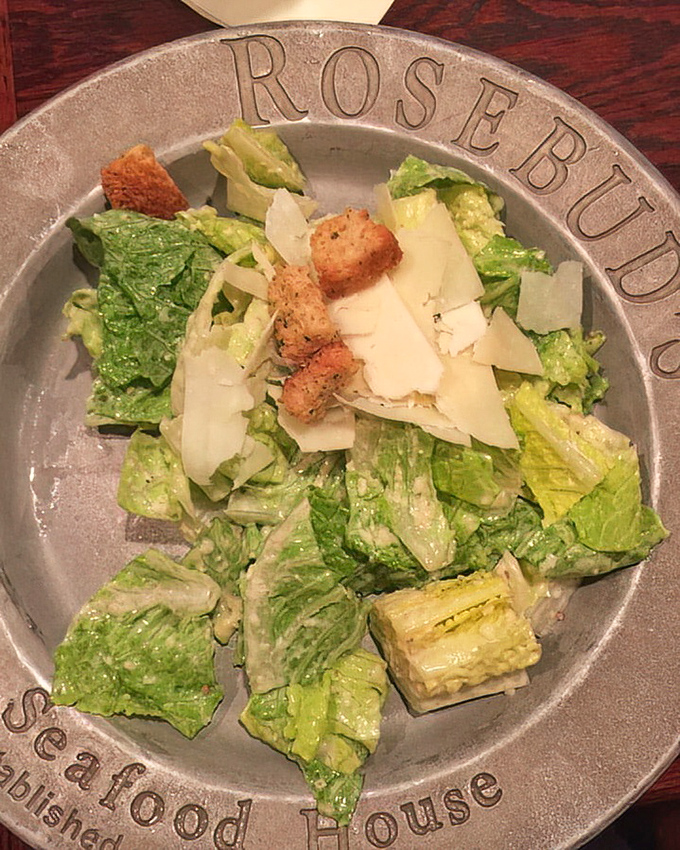 A Caesar salad that respects tradition &ndash; crisp romaine, proper dressing, and shaved Parmesan on a plate that means business.