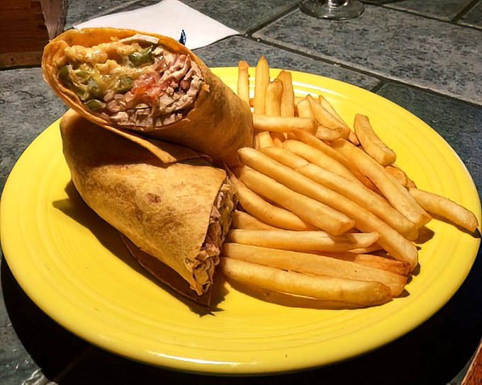 The chicken wrap stands at attention beside golden fries. This isn't just lunch—it's portable engineering that keeps every delicious ingredient in perfect balance.