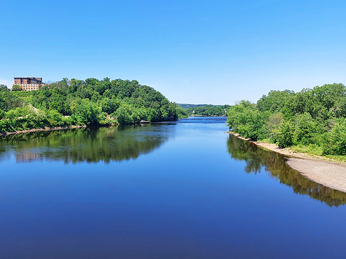 The Chippewa River stretches like a blue ribbon through lush greenery, reflecting sky and forest in its mirror-like surface&mdash;nature's perfect selfie.