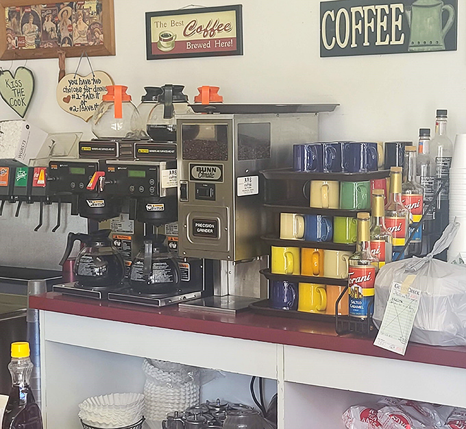 Coffee station serious enough to fuel a small army. The rainbow of mugs suggests this place understands morning rituals are sacred business.