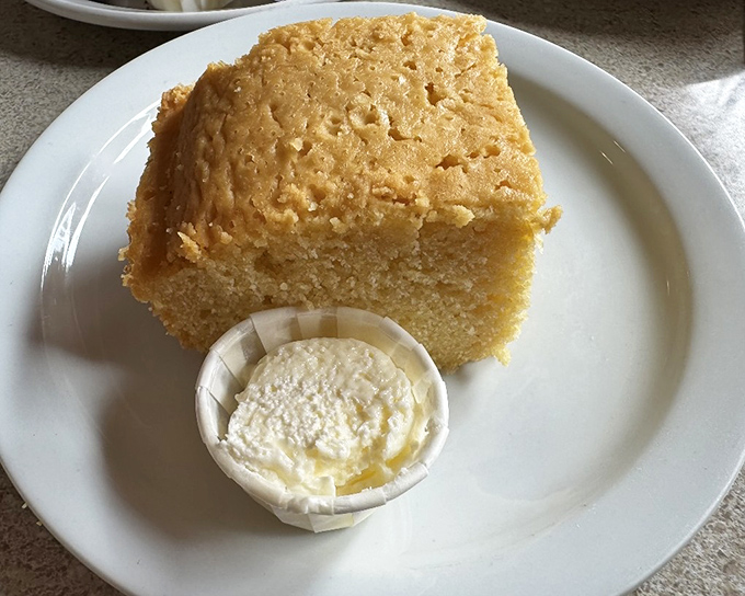 Cornbread that achieves the impossible: simultaneously moist and crumbly. That butter cup isn't just a garnish&mdash;it's your new best friend.