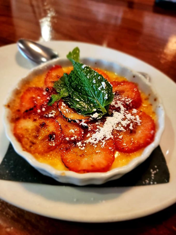 This cr&egrave;me br&ucirc;l&eacute;e isn't just dessert, it's edible sunshine &ndash; caramelized perfection topped with fresh berries and a mint leaf crown.