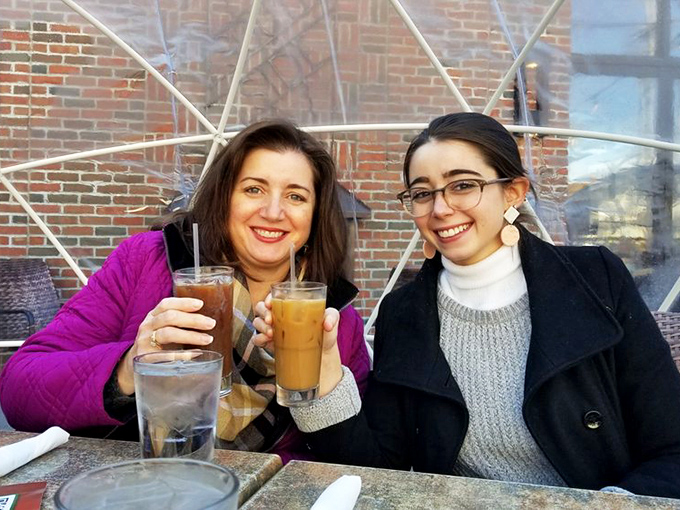 Pure joy captured in a moment – friends sharing drinks and creating memories over exceptional comfort food.