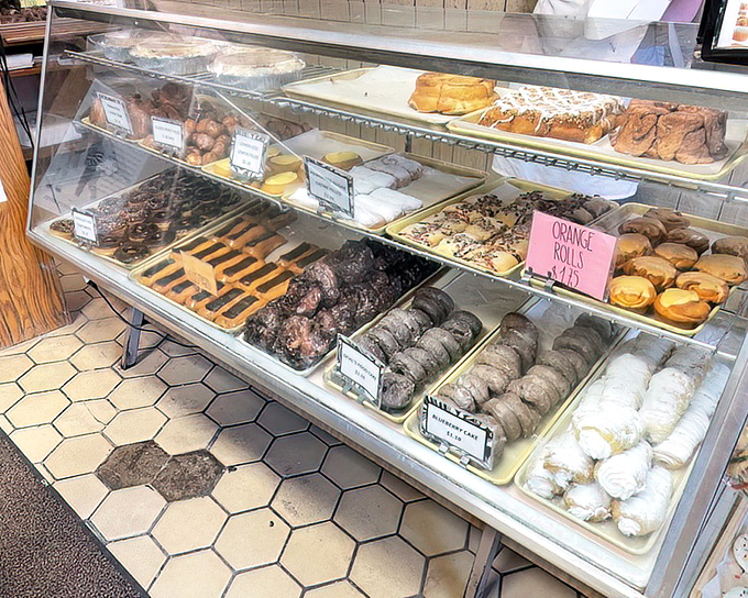 The display case&mdash;a glass-fronted gallery where art is measured not in brushstrokes but in sprinkles, glazes, and the occasional strategic drizzle.