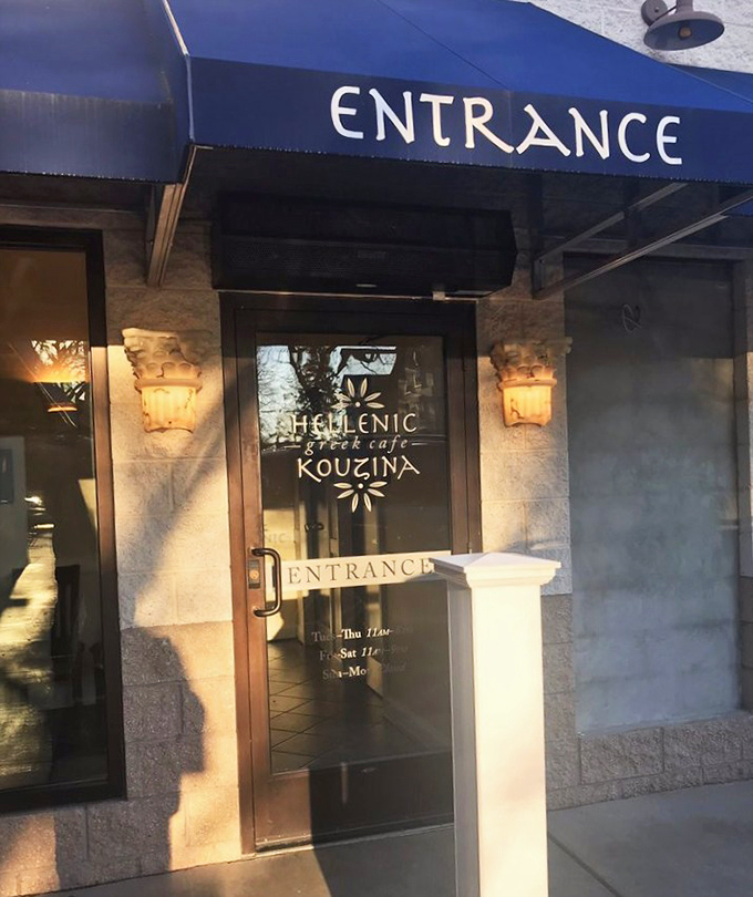 A blue awning welcomes you to flavor paradise. The entrance to Hellenic Kouzina promises an authentic Greek experience from the moment you arrive.