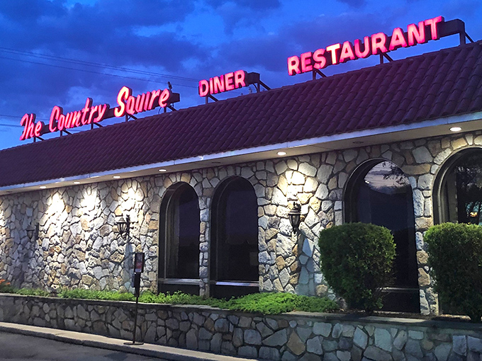 As evening falls, the Country Squire's neon glow transforms from mere signage to a beacon of culinary comfort against the twilight sky&mdash;a promise of warmth inside.
