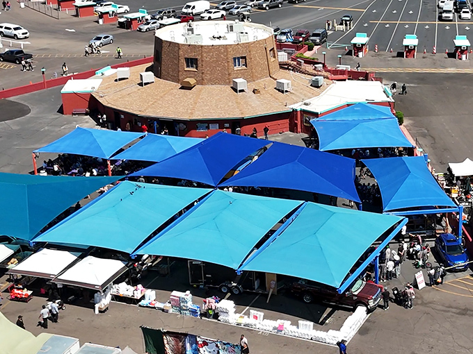 The market's distinctive architecture and blue canopies create a desert oasis of commerce, visible from across the sprawling parking lot.