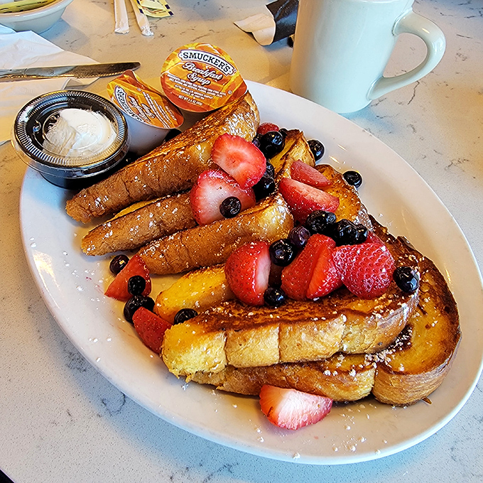 French toast that's dressed for success with berries, powdered sugar, and enough fruit to convince yourself it's practically health food.