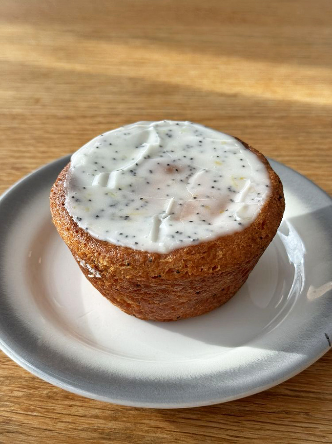 This lemon poppy seed muffin, with its perfect dome and glistening glaze, isn't just gluten-free &ndash; it's a tiny masterpiece of texture and bright citrus flavor.