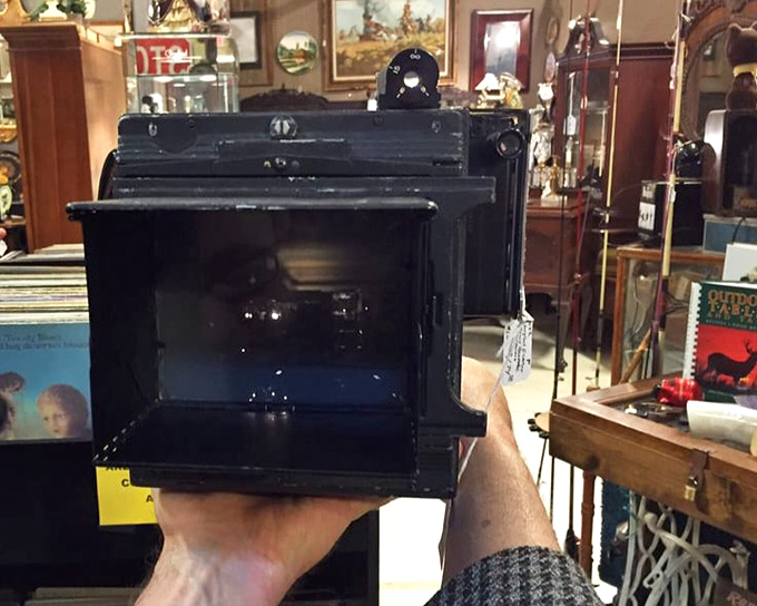 Someone's holding history in their hands! This vintage Graflex camera once captured moments that are now themselves antiques.