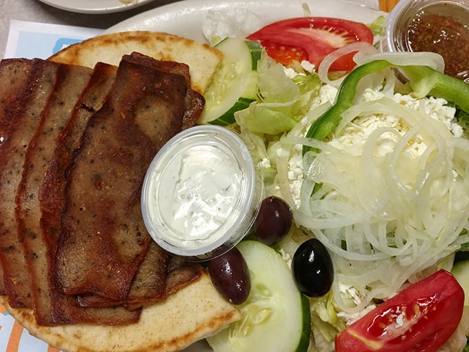 A proper gyro that transports your taste buds to Greece without the airfare—tender meat, fresh vegetables, and tzatziki creating perfect harmony on a pita.