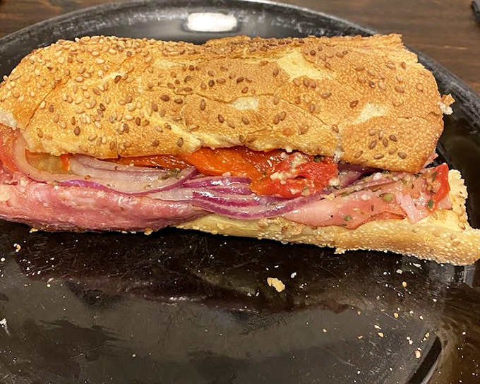 The Italian grinder in its natural habitat—sesame-seeded roll barely containing the generous layers of meat, a sandwich that demands respect and napkins.