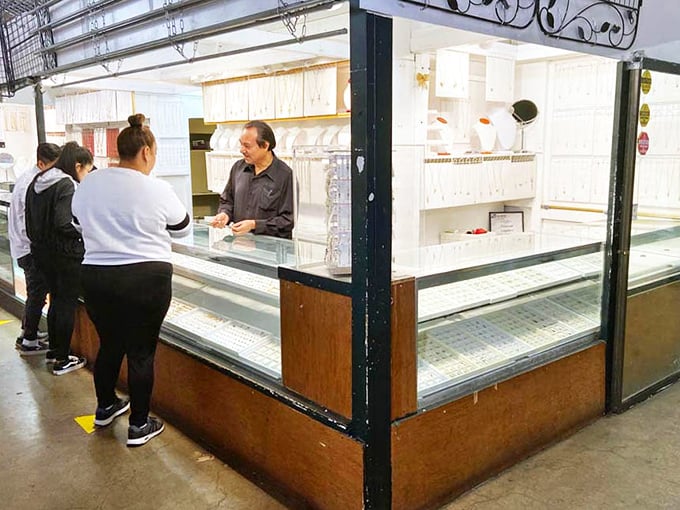 The jewelry counter gleams with possibility, where special occasion splurges and everyday sparkle await behind glass, guarded by a shopkeeper who knows every piece's story.
