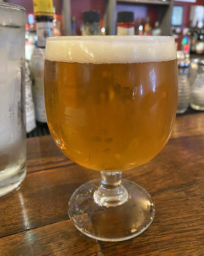 A perfectly poured craft beer catches the light like liquid amber &ndash; the ideal companion for your burger adventure.