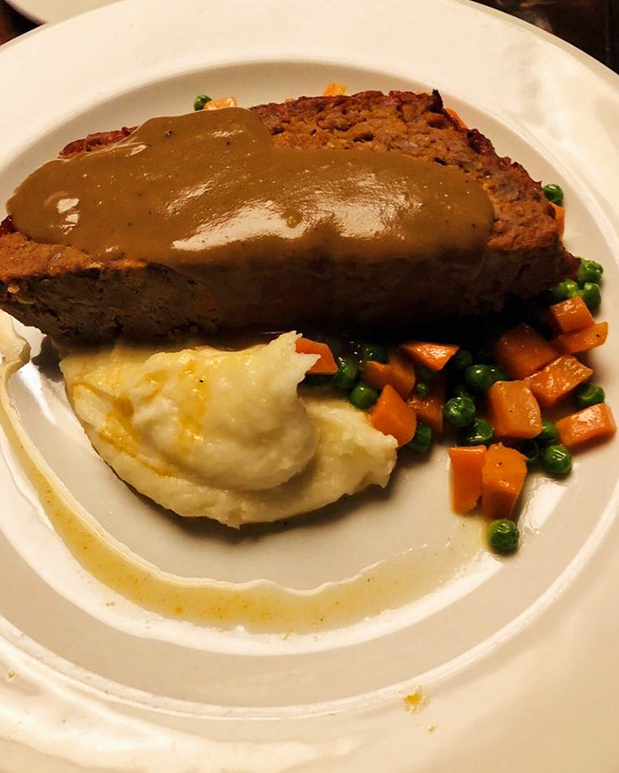 Classic meatloaf with gravy, mashed potatoes, and vegetables proves comfort food can be restaurant-quality perfection.