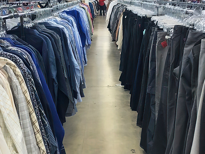 The men's department stretches into infinity, a canyon of collared shirts and slacks where patient shoppers can build entire wardrobes for the price of one mall outfit.