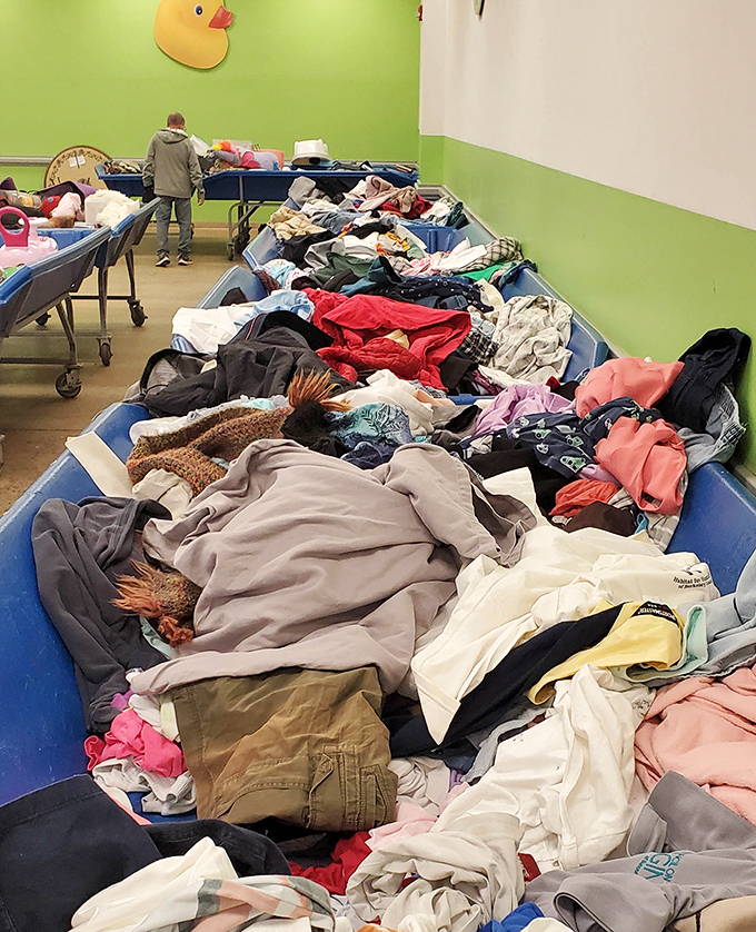 The famous bins in their natural state—a textile mountain range where determined shoppers mine for hidden gems beneath layers of discarded sweaters and forgotten jeans.
