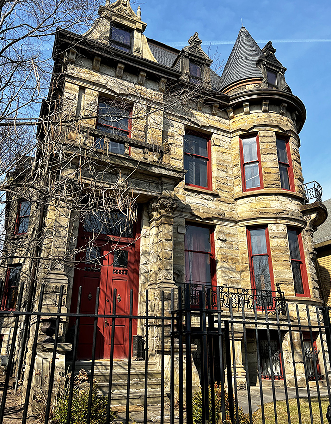 Morning light softens the castle's imposing features, though those turrets and red-trimmed windows maintain their Gothic charm even under blue skies.