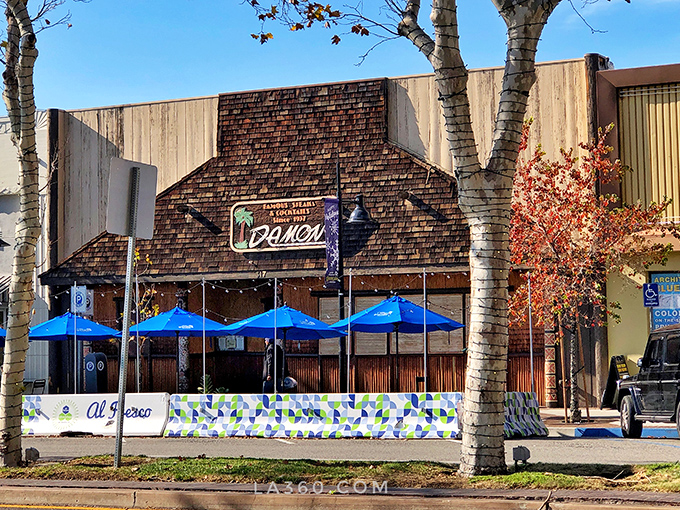 Blue umbrellas and tiki architecture create a sidewalk preview of the Polynesian paradise waiting inside – no passport required.