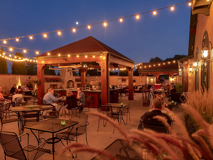 As twilight falls, the patio transforms into an enchanted garden where string lights twinkle above conversations that nobody wants to end.