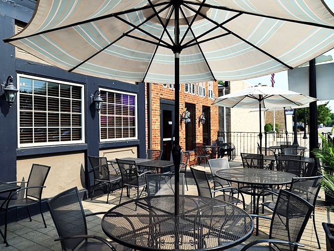Patio dining at its finest: umbrella-shaded tables where summer breezes mingle with the scent of barbecue from just beyond those brick walls.