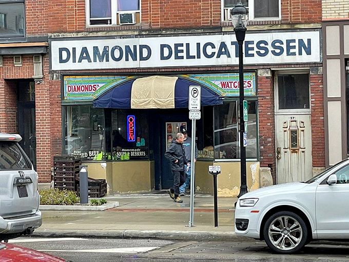 The blue and cream awning marks the spot where sandwich dreams come true, a colorful flag signaling that ordinary lunch hours can become extraordinary.