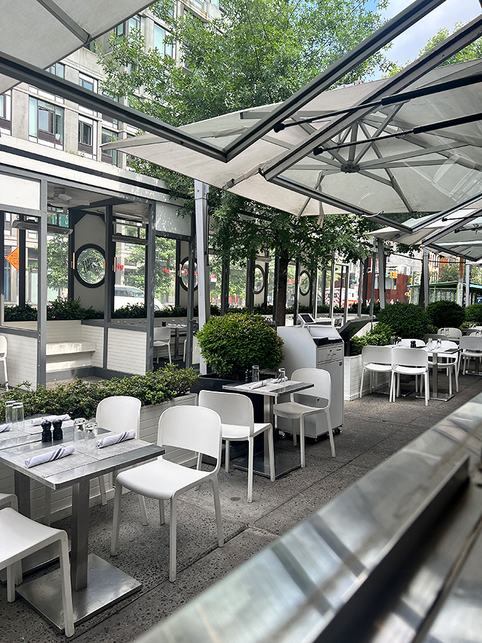 The outdoor dining area—an urban oasis where umbrellas create private kingdoms for each table. New York dining at its civilized best.