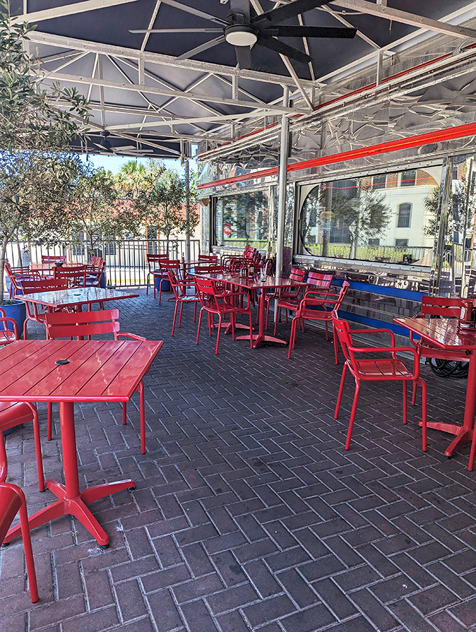 Florida sunshine and fresh air complement the diner experience on this covered patio. Red metal chairs and tables continue the theme from inside out.