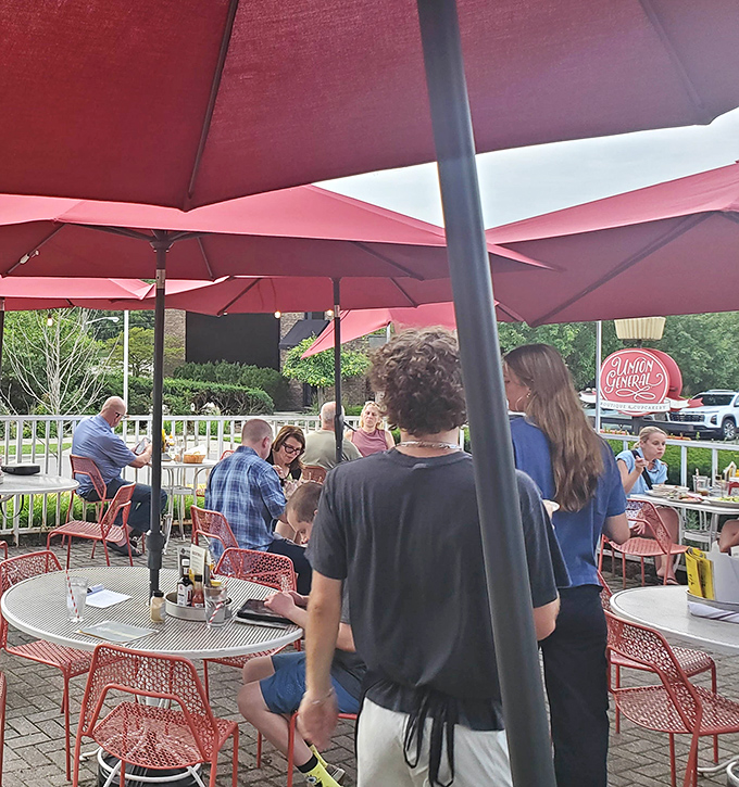 Red umbrellas create perfect outdoor dining spaces where great food meets fresh air and good company.