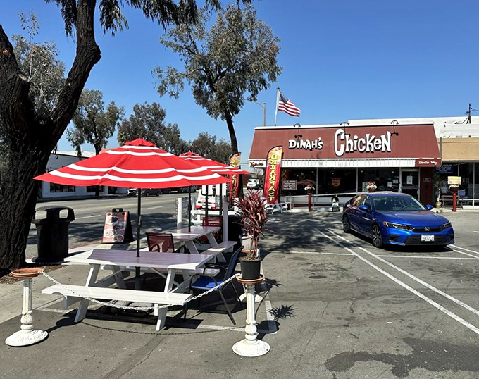 Outdoor seating under red umbrellas provides the perfect spot to enjoy your chicken feast while soaking up that California sunshine.