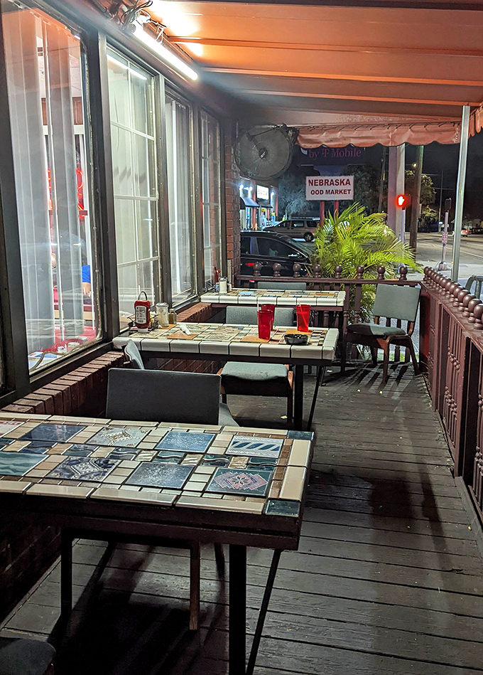 Night falls but the porch lights glow, illuminating outdoor tables where late-night conversations flow as freely as the coffee.