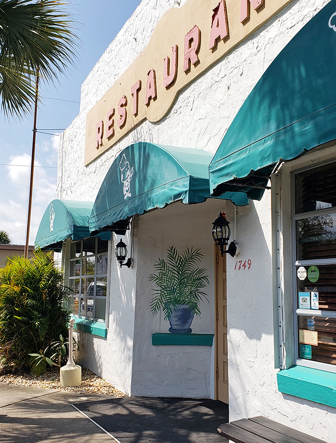 That "RESTAURANT" sign has been guiding hungry travelers to this spot for years. The teal awnings and white walls say "Florida" without a single flamingo in sight.